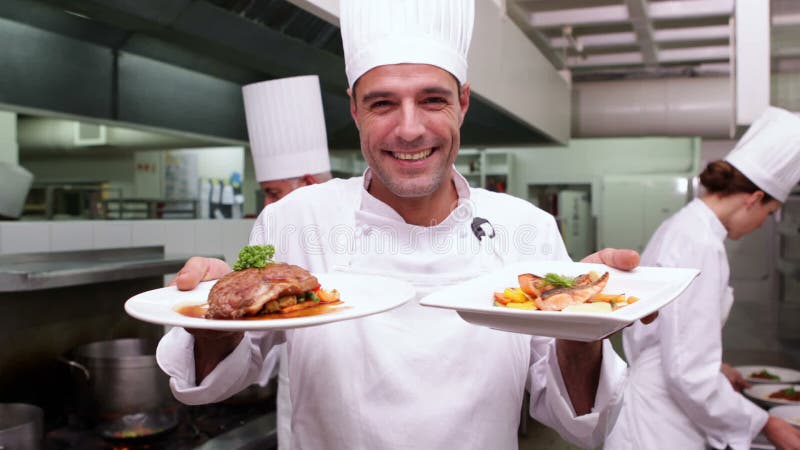 Smiling Handsome Chef Showing Two Dishes To Camera Stock Footage ...