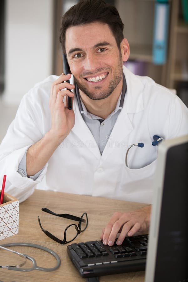 Smiling Handsome Doctor Using Computer and Smartphone Stock Image ...