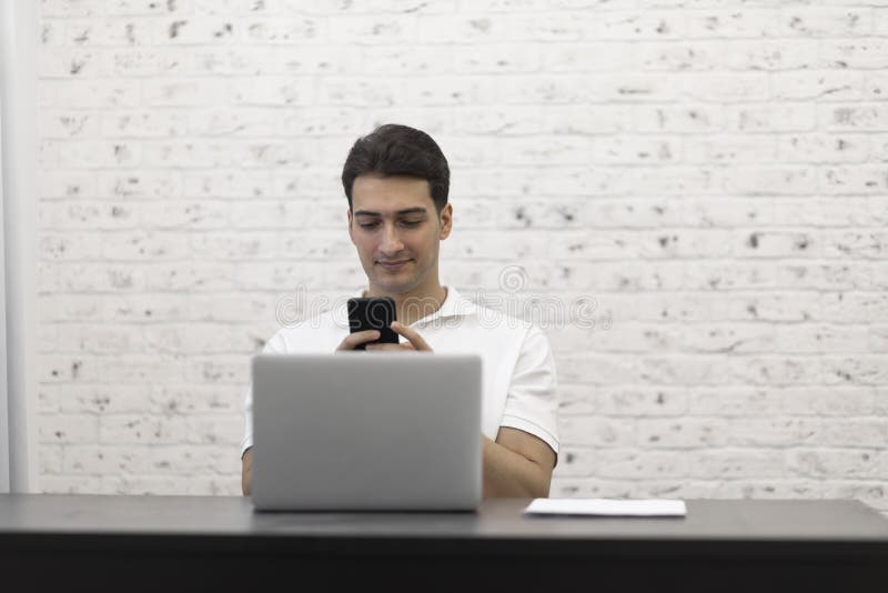 Smiling Handsome Man Sitting Working on Notebook and Smartphone at Home ...