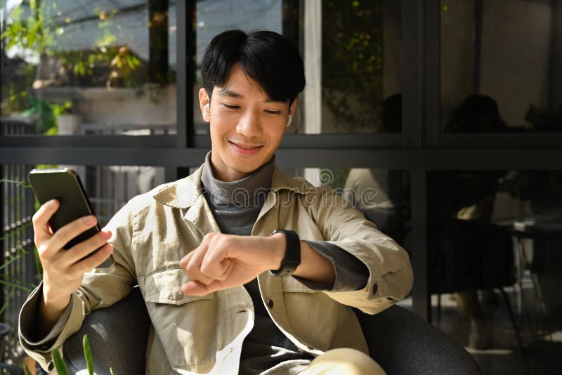 Smiling Handsome Man Using Smart Phone and Checking Arrival Time on His ...