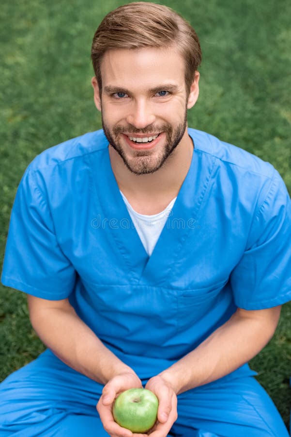 Smiling Handsome Medical Student Holding Apple in Hands and Looking ...
