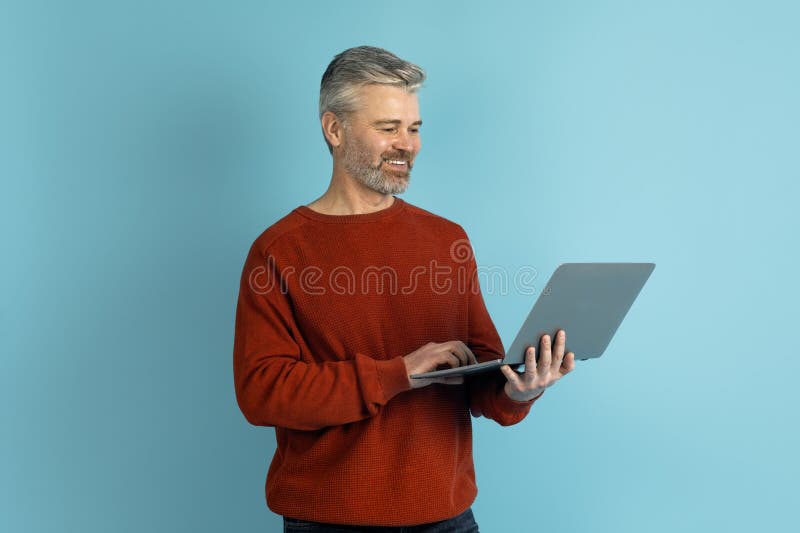 Smiling Handsome Middle Aged Man Using Computer on Blue Stock Image ...