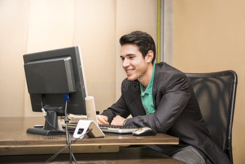 Smiling Handsome Young Businessman Sitting at Desk in Office Stock ...