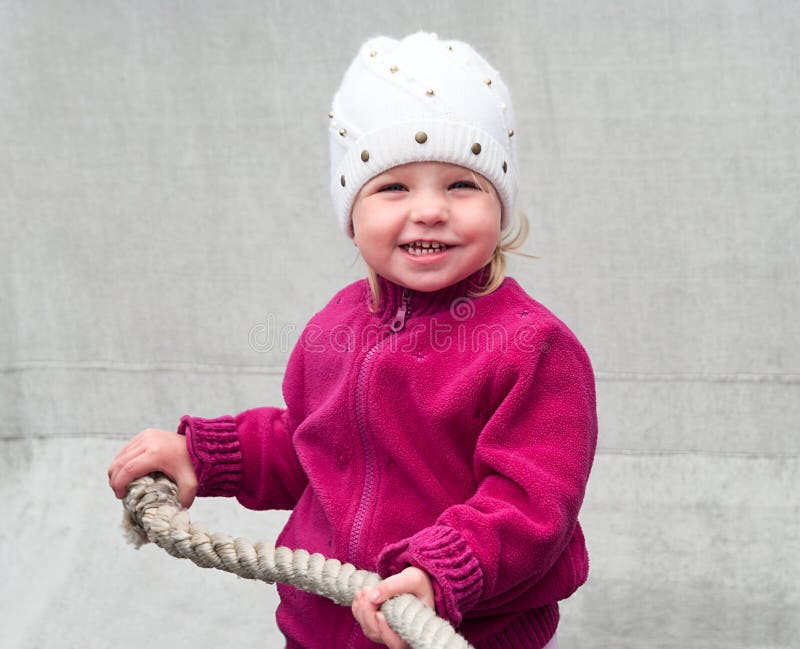Smiling And Happy Girl Holding On To The Rope Looking At Camera Stock
