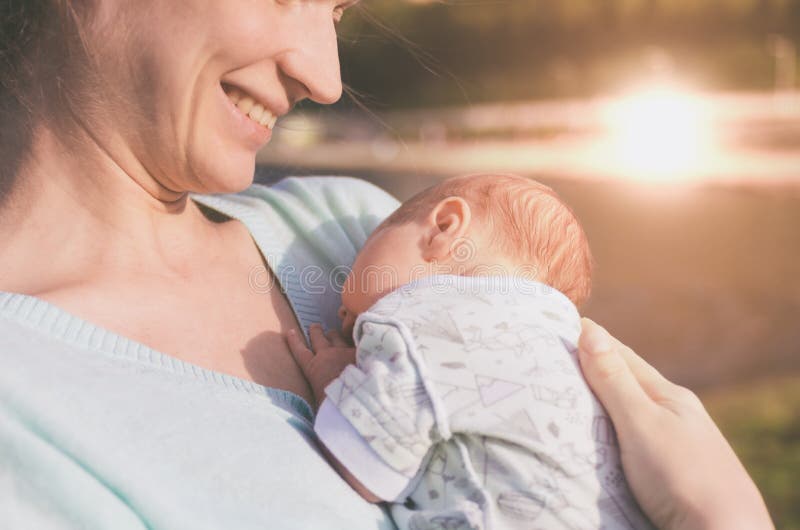 Smiling Happy Mom Holding a Sleeping Baby on Her Chest Stock Photo ...