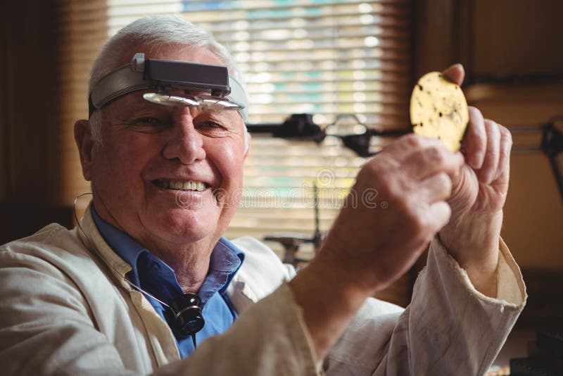 Smiling Horologist Examining Clock Parts in Workshop Stock Photo ...