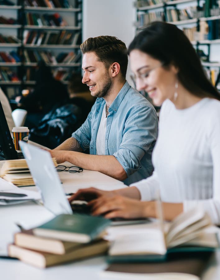 Smiling Intelligent Student Typing on Laptop in Library Stock Photo ...