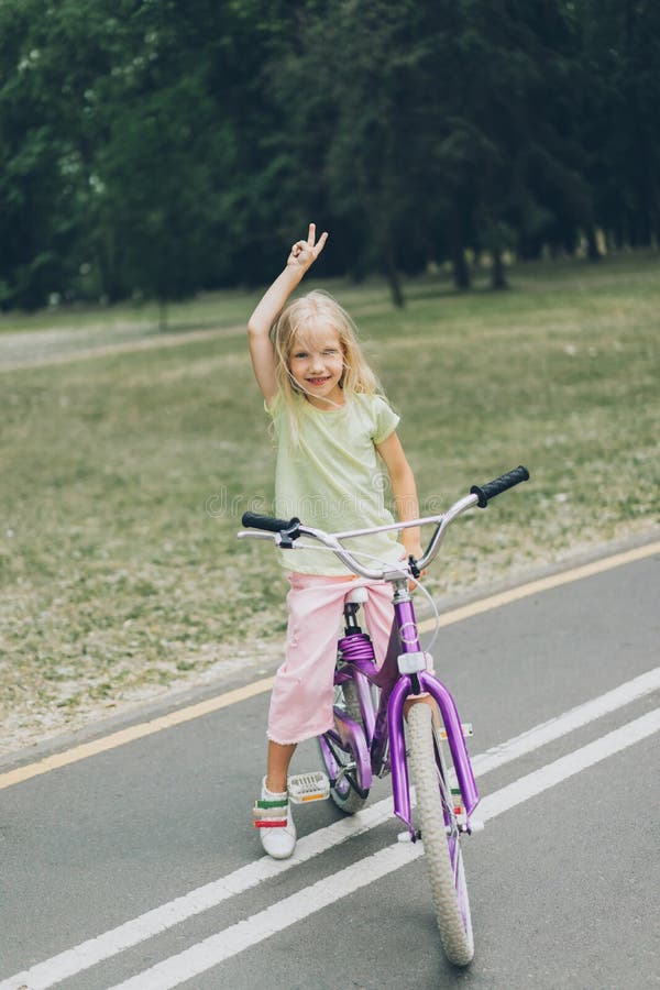 Smiling Kid on Bicycle Showing Peace Sign while Standing on Road Stock ...
