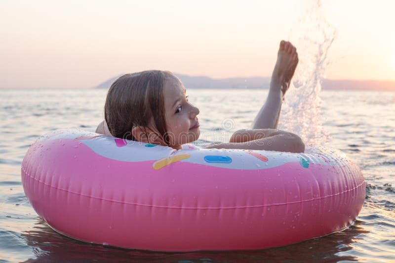 Smiling Little Girl on Inflatable Ring Looking at Camera. Child on Sea ...