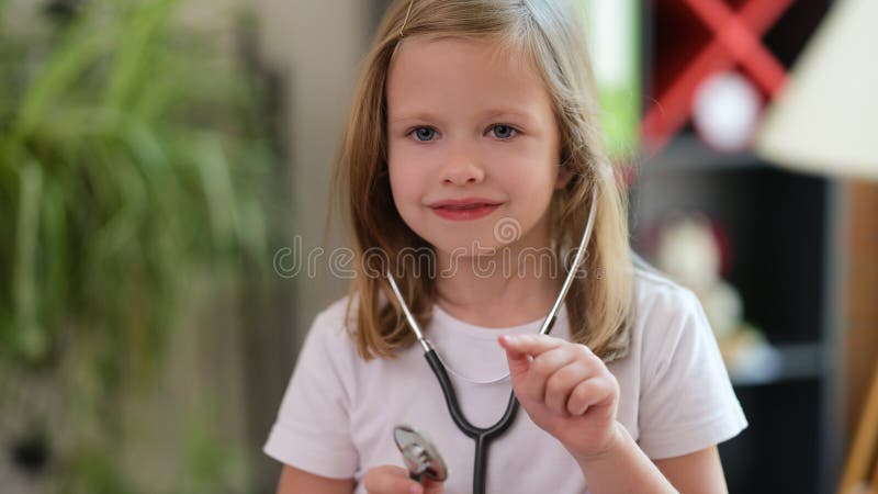 Smiling Little Girl Using Medical Stethoscope and Pointing with Finger ... Smiling Little Girl Using Medical Stethoscope and Pointing with Finger ...