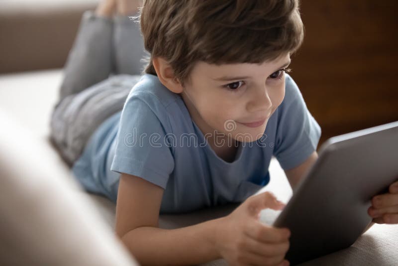 Smiling Little School Boy Playing Online Game on Computer Tablet. Stock ...