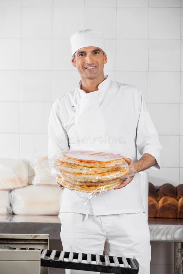 Smiling Male Baker Holding Packed Pizza Breads Stock Image - Image of ...