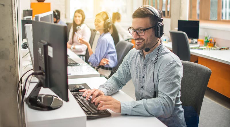 Smiling Male Call Center Worker Accompanied by His Team in Row at ...