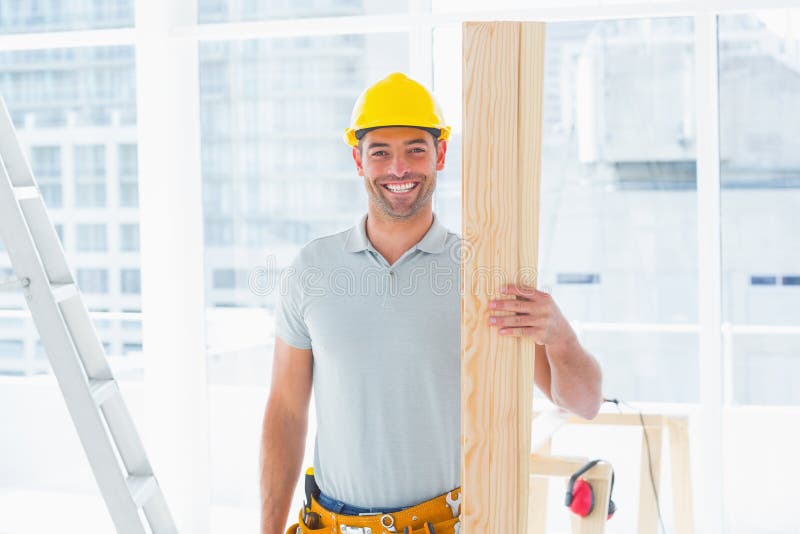 Smiling Male Carpenter Holding Plank in Building Stock Image - Image of ...