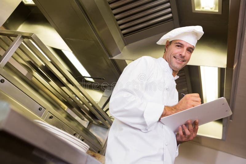 Smiling Male Cook Writing on Clipboard in Kitchen Stock Image - Image ...