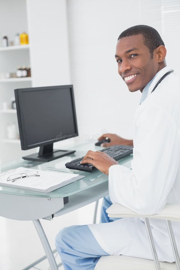 Smiling Male Doctor Using Computer at Medical Office Stock Image ...