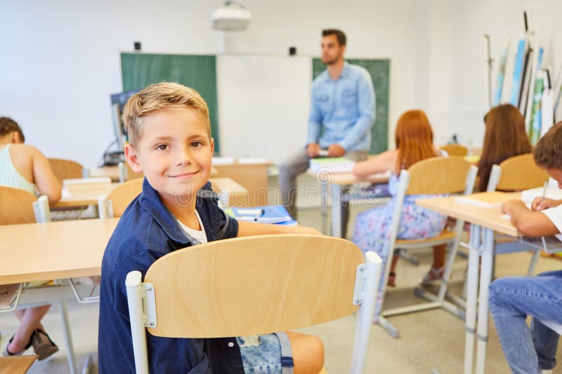 Smiling Male Elementary Student Sitting in Classroom Stock Photo ...