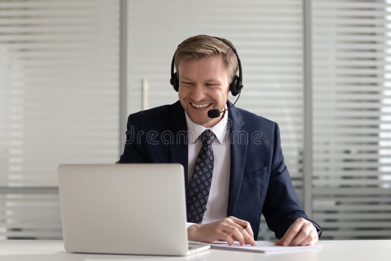 Smiling Male Employee Make Notes Having Video Call With Client Stock