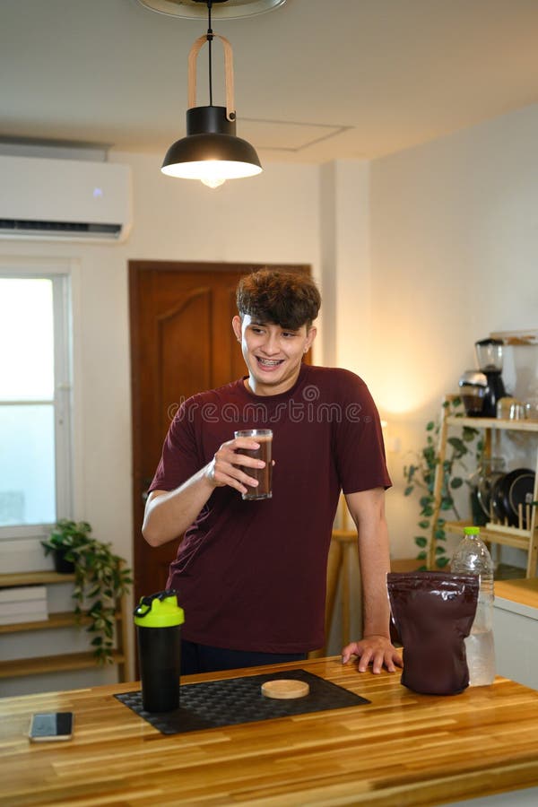 Smiling Male Holding a Glass of Chocolate Protein Drink after Exercise ...