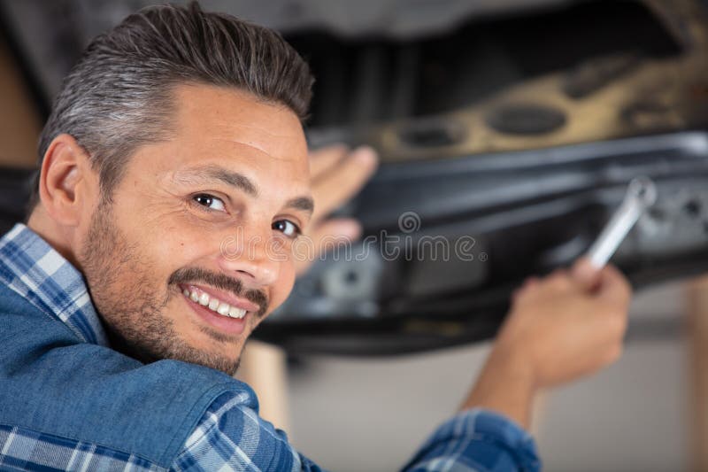 Smiling Male Mechanic Using Spanner Stock Photo - Image of nuts, casual ...