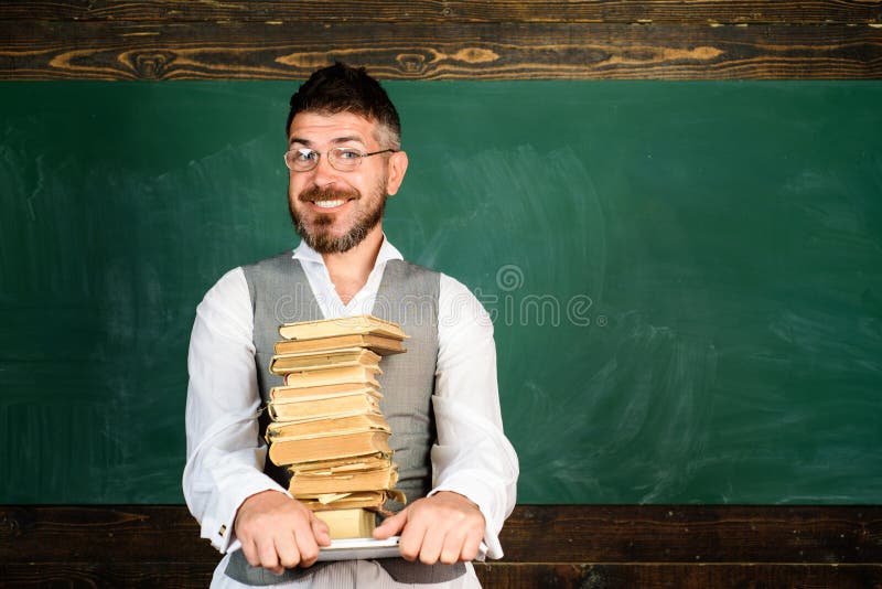 Smiling Male Student with Notebook and Stacks of Books in Front of ...