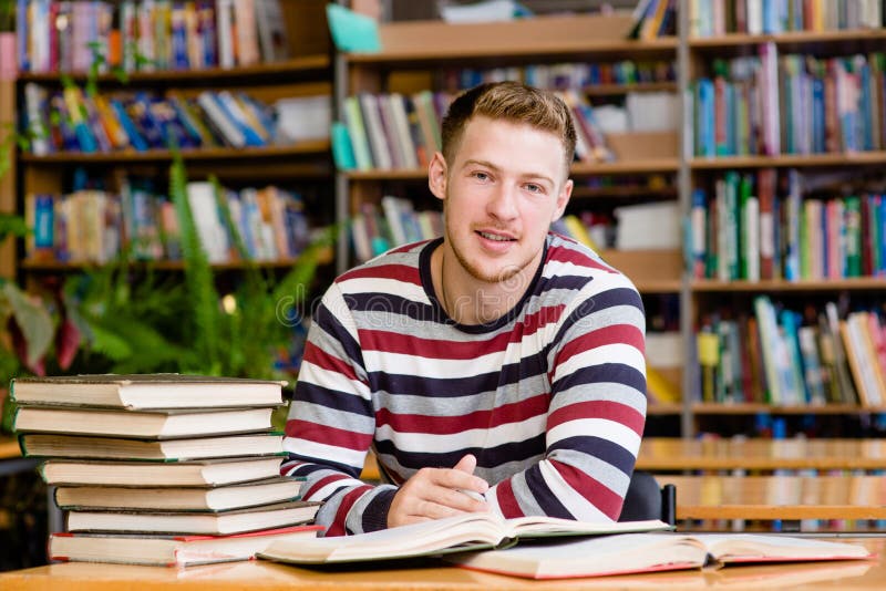 Smiling Male Student with Open Book Working in a Library Stock Image ...