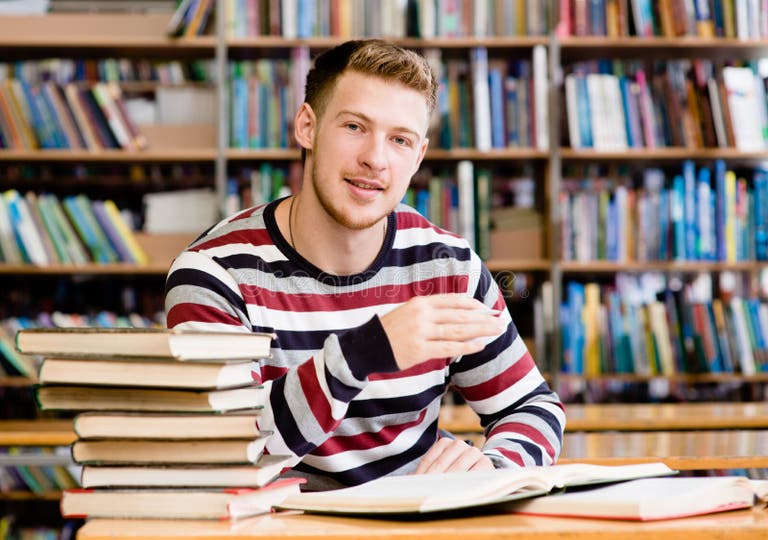 Smiling Male Student with Open Book Working in a Library Stock Photo ...