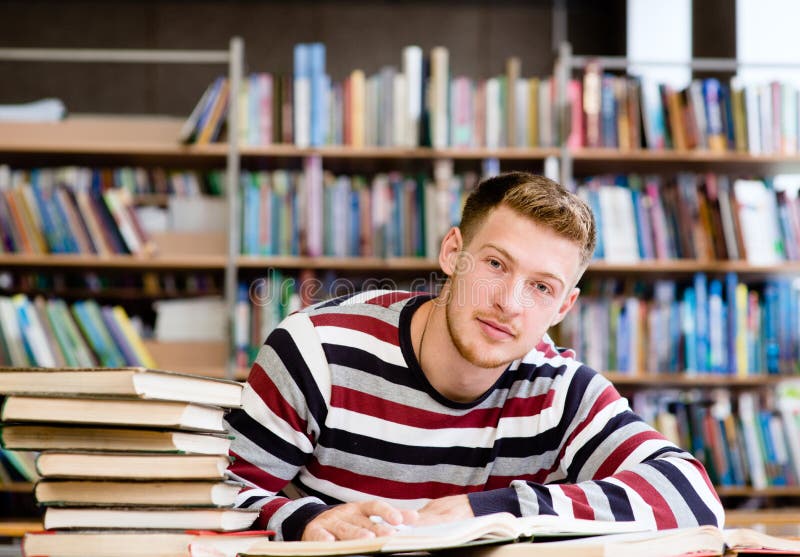 Smiling Male Student with Open Book Working in a Library Stock Photo ...