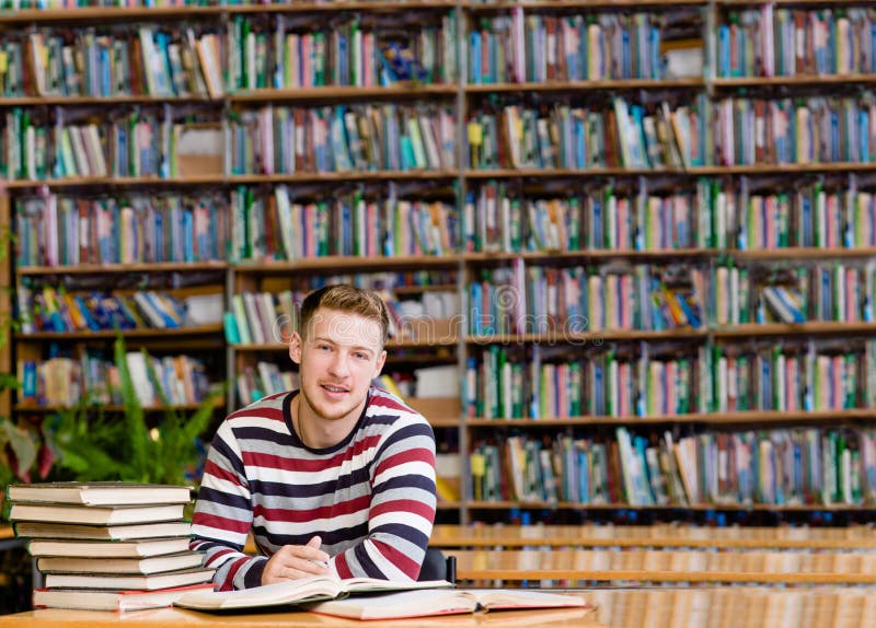 Smiling Male Student with Open Book Working in a Library Stock Image ...
