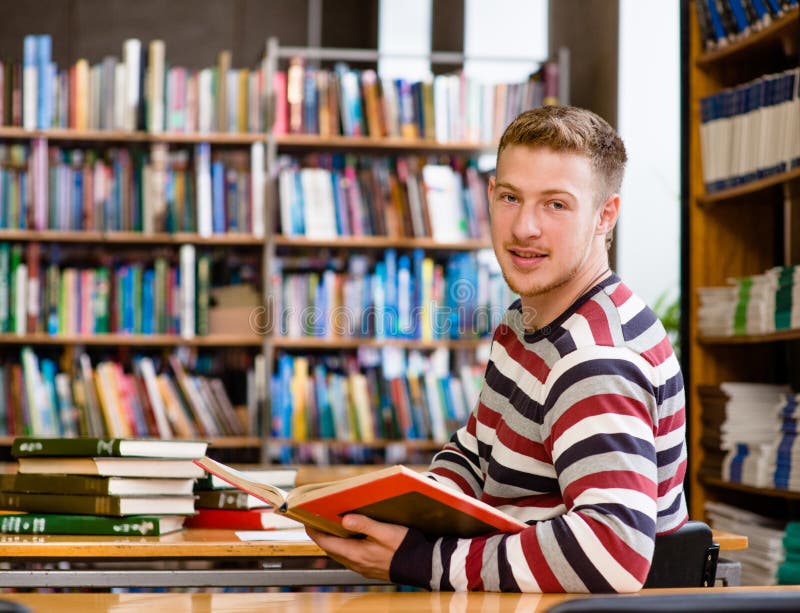 Smiling Male Student with Open Book Working in a Library Stock Image ...