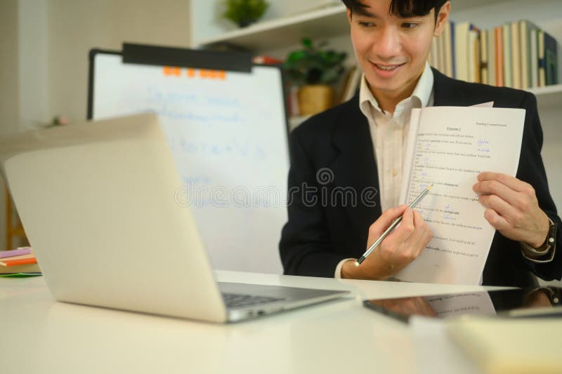 Smiling Male Tutor Explaining a Worksheet To Student during an Online ...