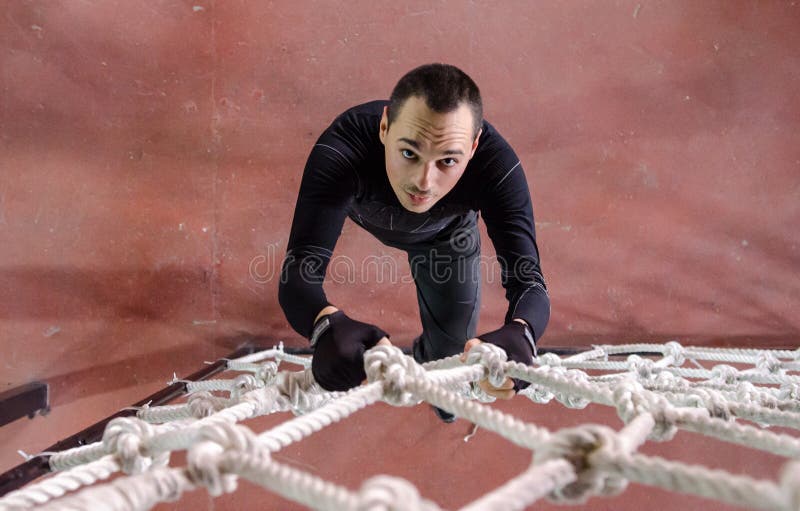 Smiling Man Climbing on Rope Net Stock Image - Image of bootcamp ...