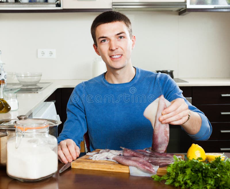 Smiling Man Cooking Raw Squid Stock Photo - Image of holiday ...