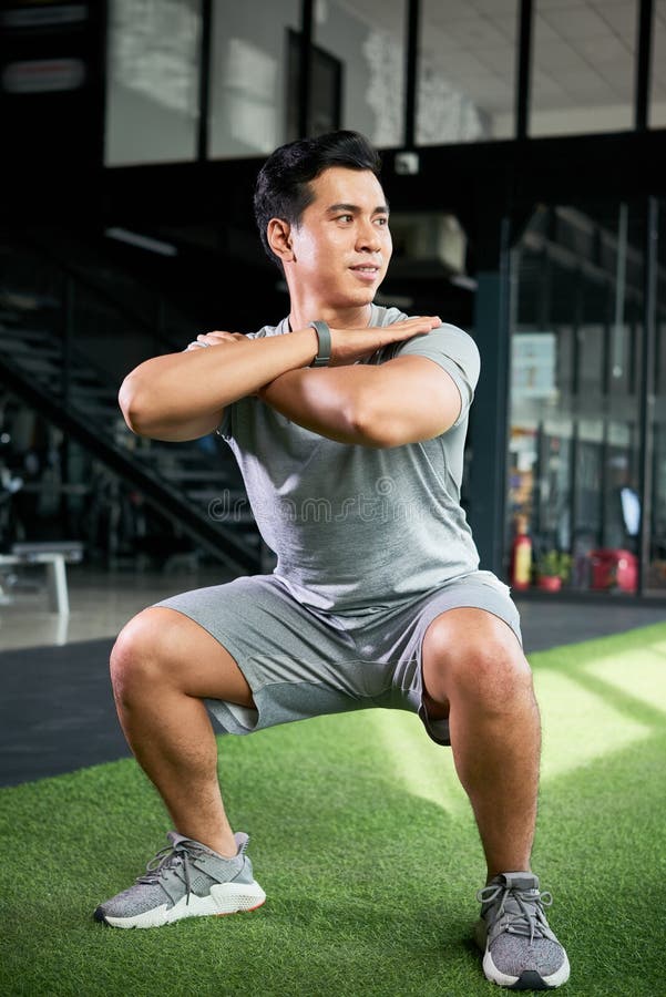 Smiling man doing squats stock image. Image of squat - 139977983
