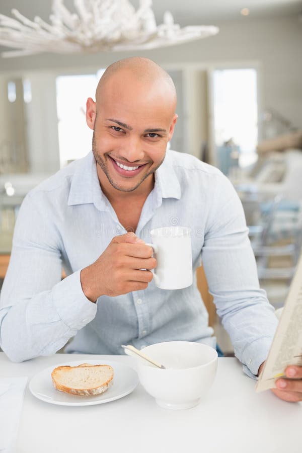 Smiling Man Drinking Coffee while Reading Newspaper at Home Stock Photo ...