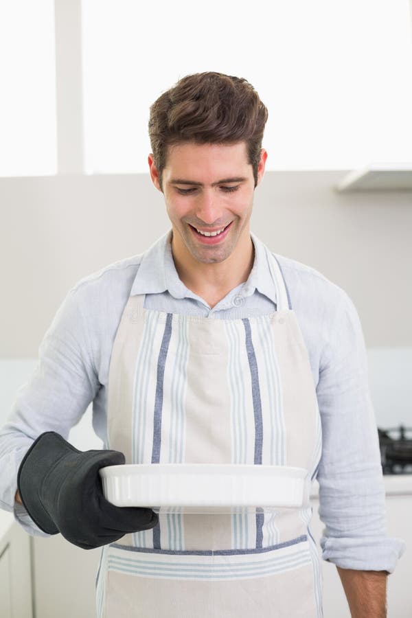 Smiling Man Holding a Baking Dish in Kitchen Stock Image - Image of ...