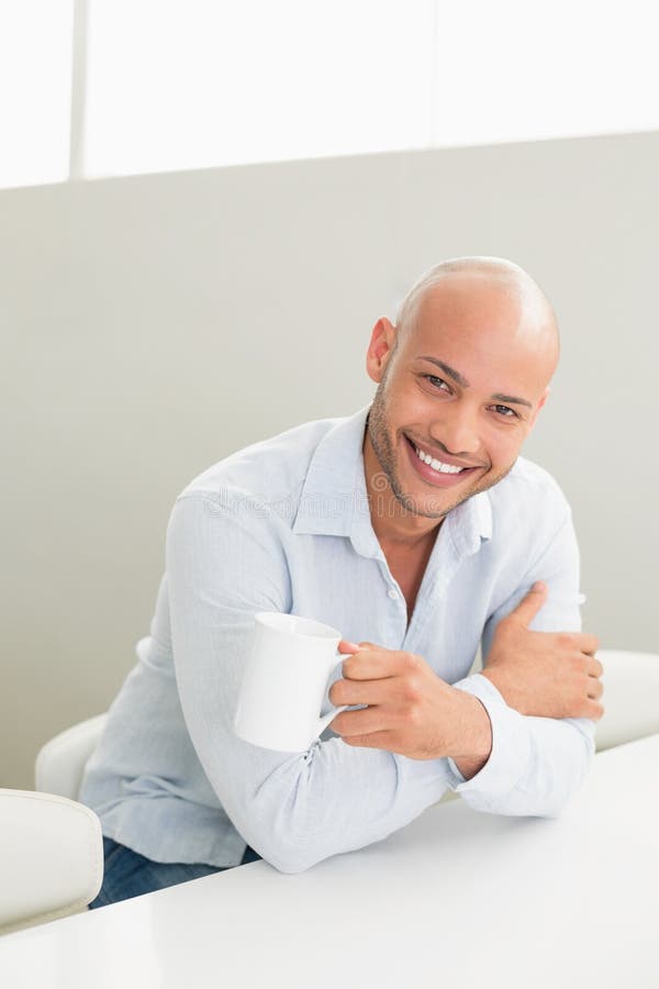 Smiling Man Holding Coffee Cup at Home Stock Photo - Image of sitting ...