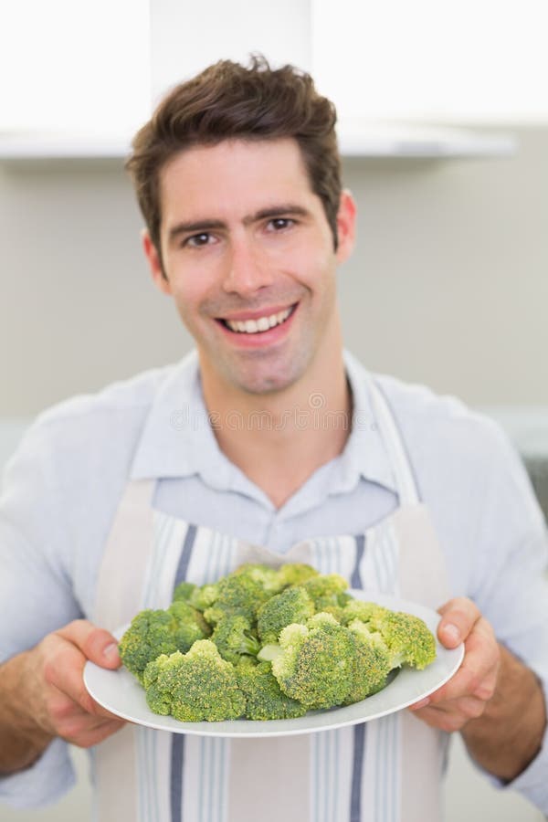 Smiling Man Holding a Plate of Broccoli in Kitchen Stock Photo - Image ...