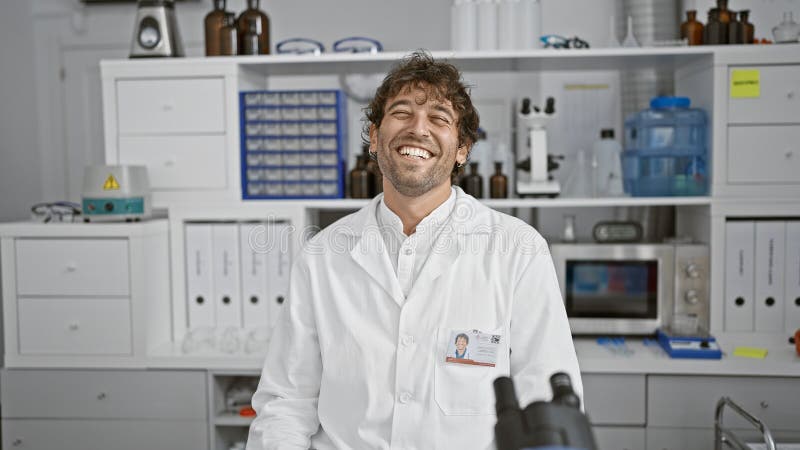 Smiling Man in Lab Coat Standing Inside a Laboratory with Equipment and ...