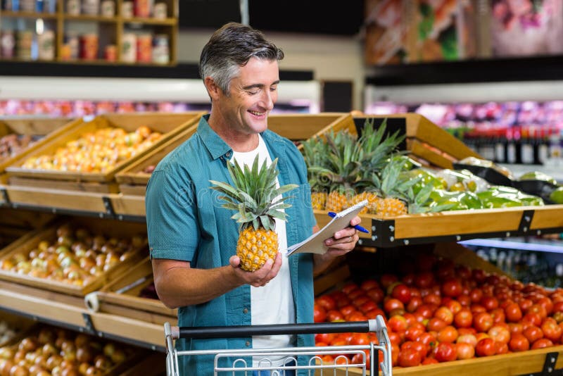 Smiling Man Looking at His List Stock Photo - Image of shelf, shopping ...