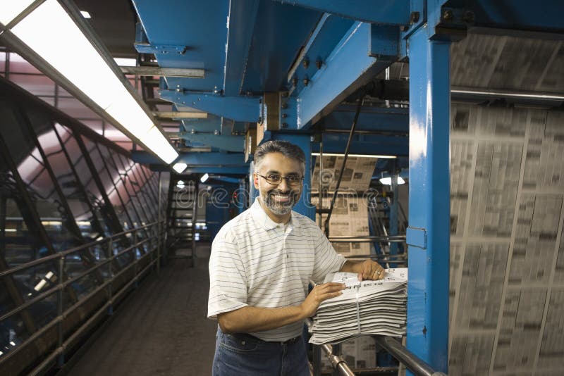 Man Carrying Newspaper Stack in Factory Stock Photo - Image of bundle ...