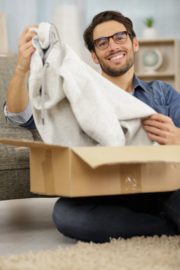 Smiling man opening box stock photo. Image of comfort - 263893236