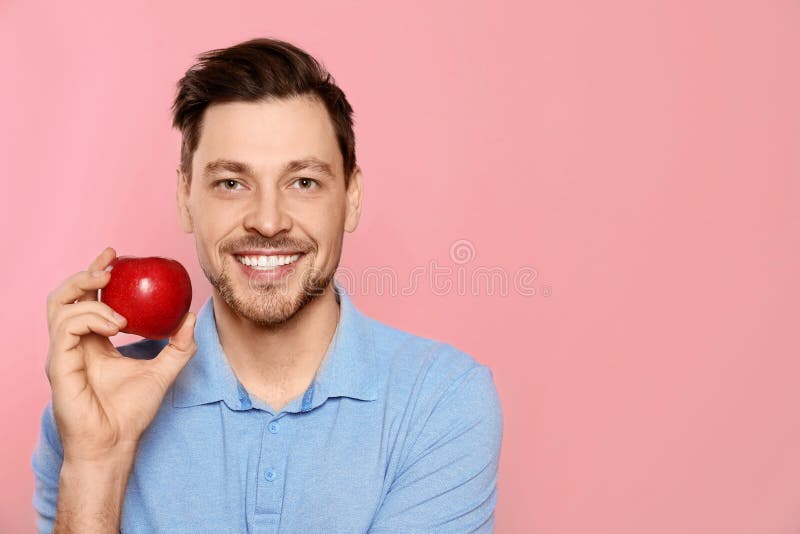 Smiling Man with Perfect Teeth and Red Apple on Color Background. Stock ...