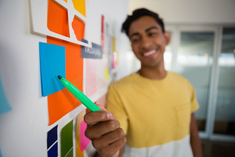 Smiling Man Pointing at Sticky Notes with Felt Tip Pen in Office Stock ...