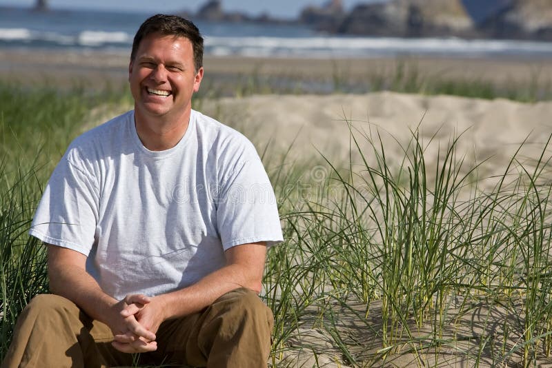 Smiling Man Sitting on Beach Stock Image - Image of teeth, daytime: 9798685