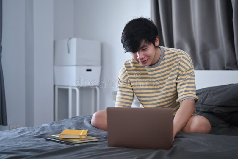 Man Sitting in Bed and Watching Something on Laptop Computer. Stock ...