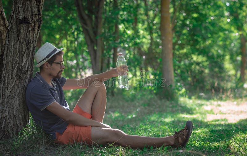 Smiling Man Sitting in Forest Looking at Camera. Stock Image - Image of ...