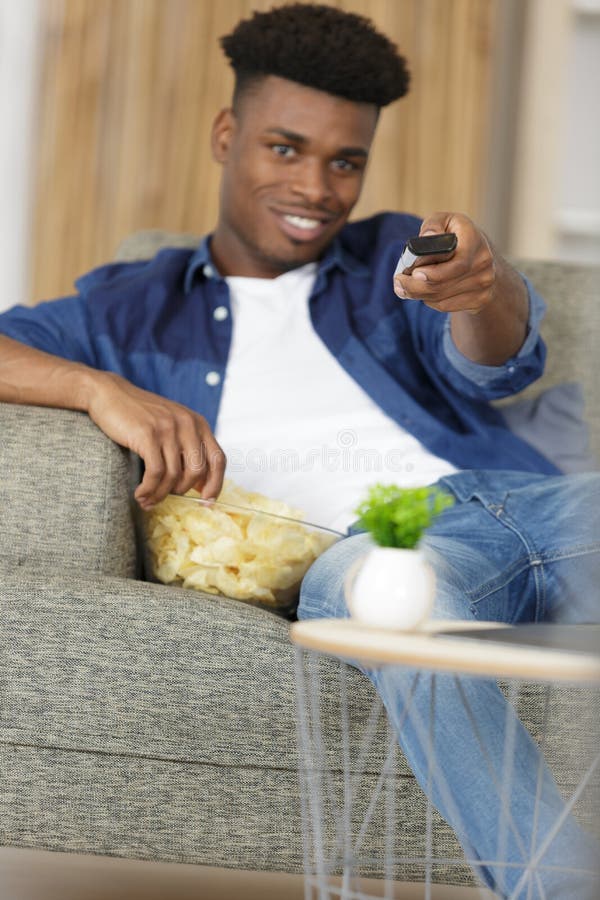 Smiling Man Sitting on Sofa Stock Photo - Image of people, adult: 148583294