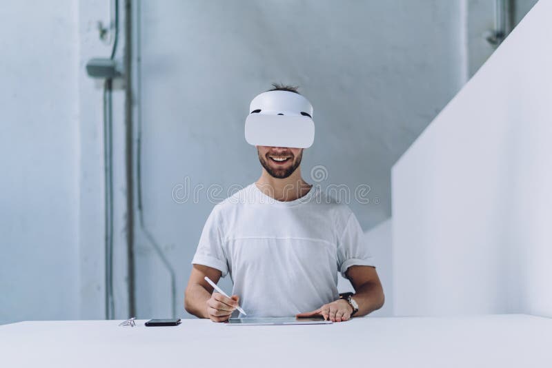 Smiling Man Sitting at Table in Virtual Reality Glasses Stock Photo ...