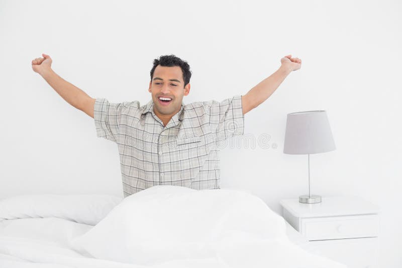 Smiling Man Stretching His Arms in Bed Stock Image - Image of ...
